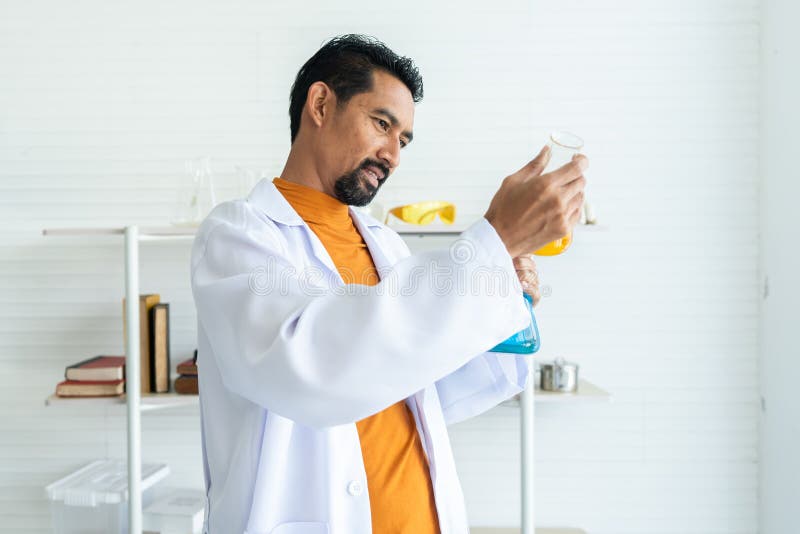 Male Teacher in White Lab Coat with Safety Glasses Using Pipette ...