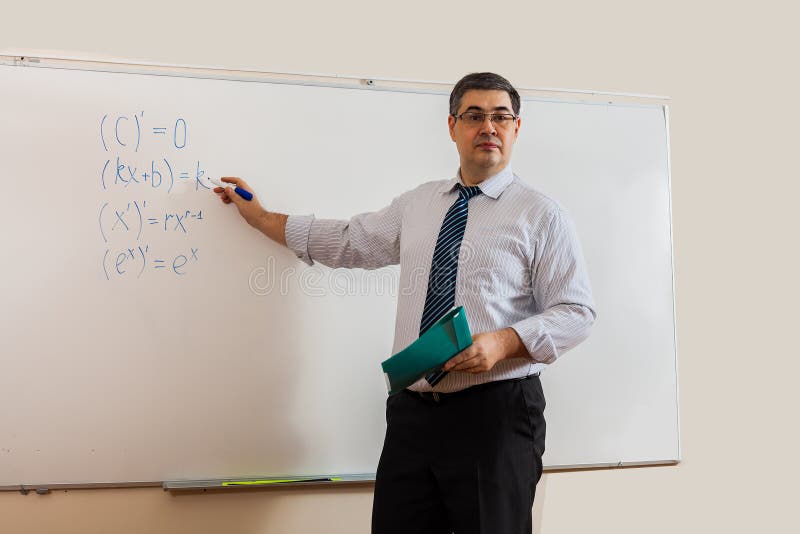 A Male Teacher Writes on a Blackboard Stock Image - Image of smiling ...