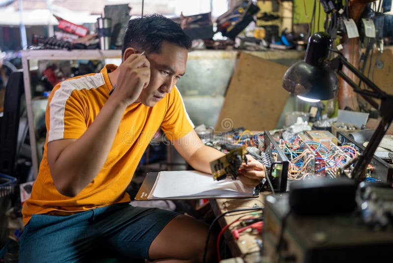 Male Technician Observing the Circuit while Working at the Workbench ...
