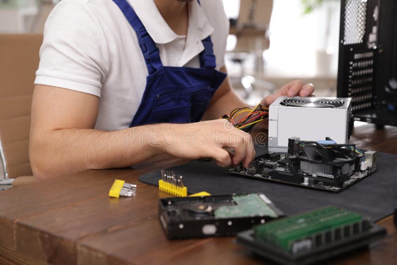 Male Technician Repairing Computer at Table Indoors Stock Photo - Image ...