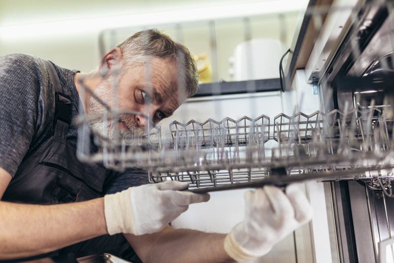 Male Technician Repairing Dishwasher in Kitchen Stock Image - Image of ...