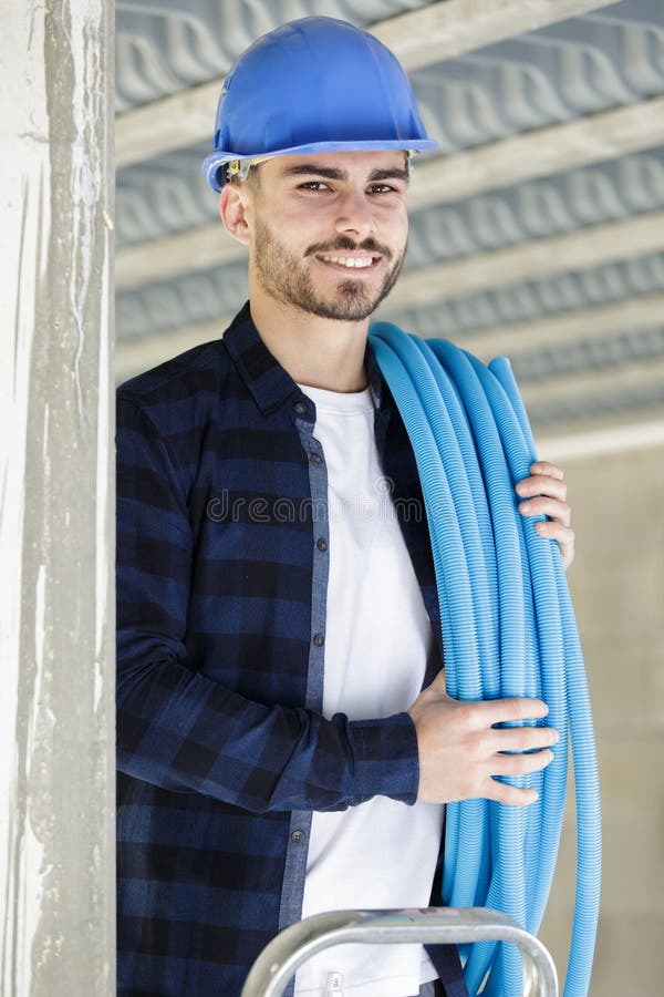Male Technician with Wire Roll Against Wall Stock Photo - Image of ...