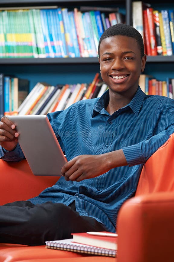 Male Teenage Student Using Digital Tablet in Library Stock Photo ...