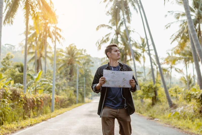 Male Traveler Holding Map for Searching Route in Forest Stock Photo ...