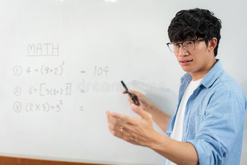 Male Tutor Standing in Front of Whiteboard and Writing Math Equations ...