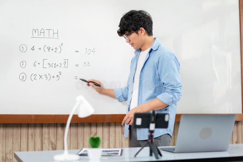 Male Tutor Standing in Front of Whiteboard and Writing Math Equations ...