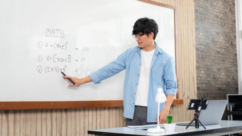 Male Tutor Standing in Front of Whiteboard and Writing Math Equations ...
