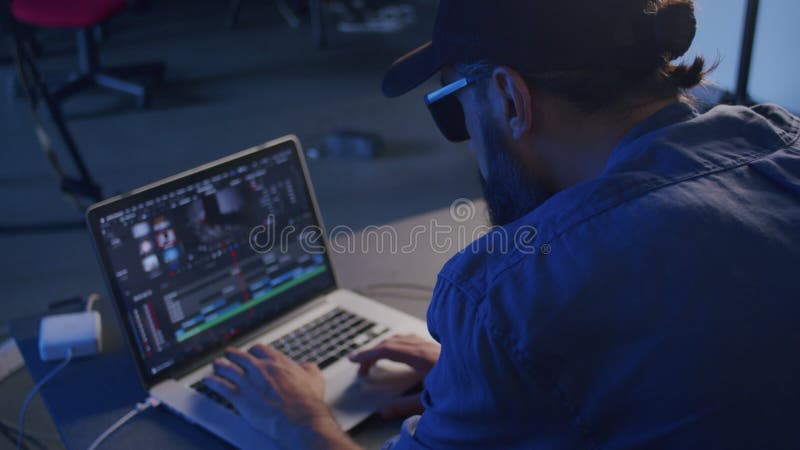 A Male Video Editor is Engaged in Processing on a Laptop in the Studio ...