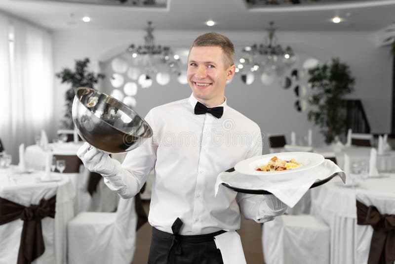 Male Waiter Opens the Lid of a Tray with a Hot Dish. Stock Photo ...