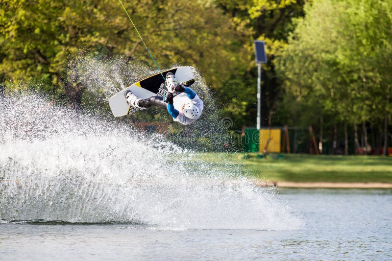 Male Wakeboarder Jumps Over Spray on Pond in Stock Photo - Image of ...