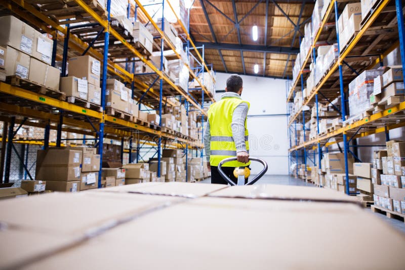 Male Warehouse Worker Pulling a Pallet Truck. Stock Photo - Image of ...