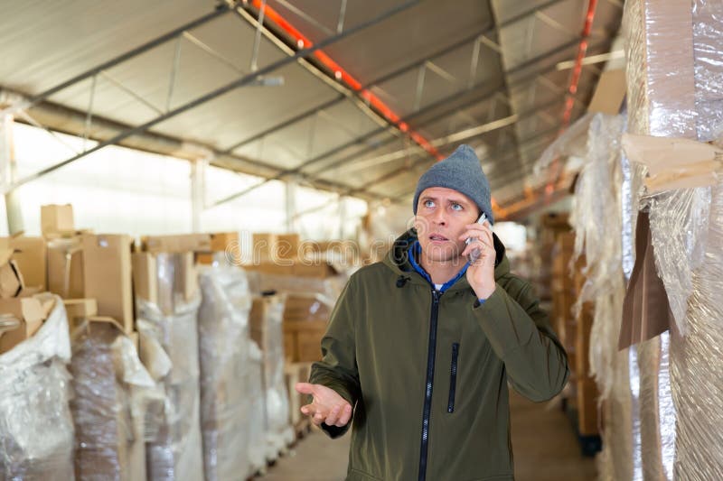 Male Warehouse Worker Talking on Cell Phone Stock Photo - Image of ...