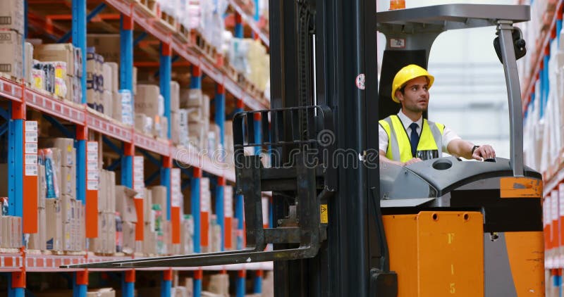 Worker with Forklift in the Warehouse. the Worker Walks through the ...