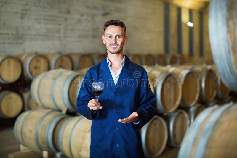 Male Winemaker in Uniform Having Glass of Wine in Hands in Cellar Stock ...