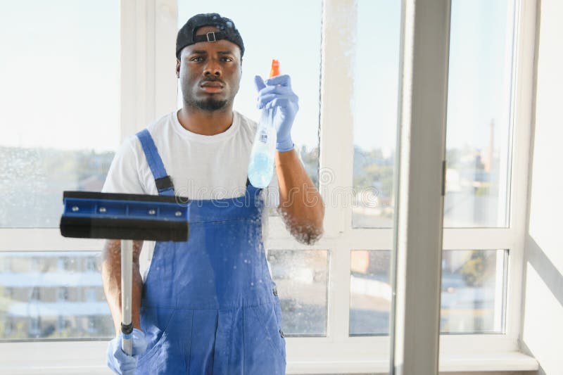 Male Worker Cleaning Glass with Squeegee and Spray Bottle Stock Image ...