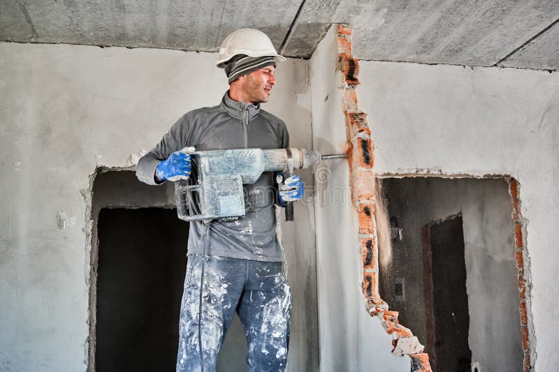 Male Worker in Construction Helmet Drilling Wall with Hammer Drill ...