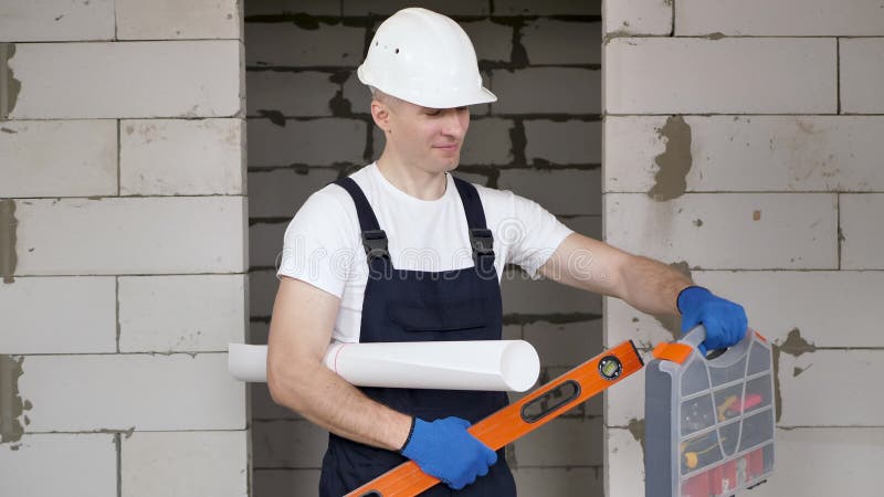 Male Worker or Construction Worker Wearing a Helmet with a Level, Tool ...