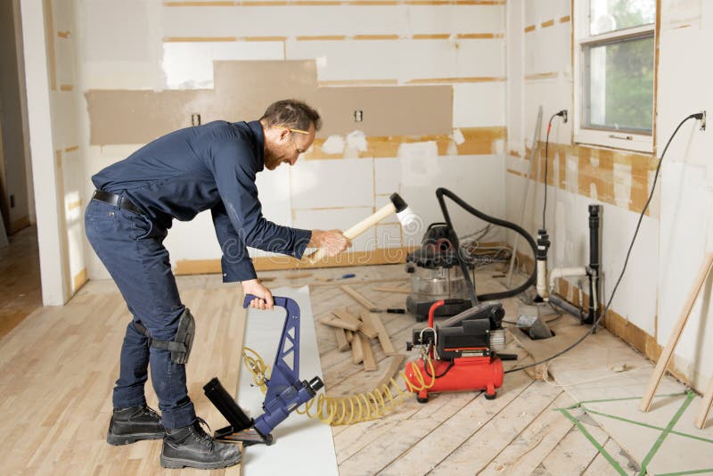 A Male Worker Install Wood Floor on a House Stock Image - Image of ...