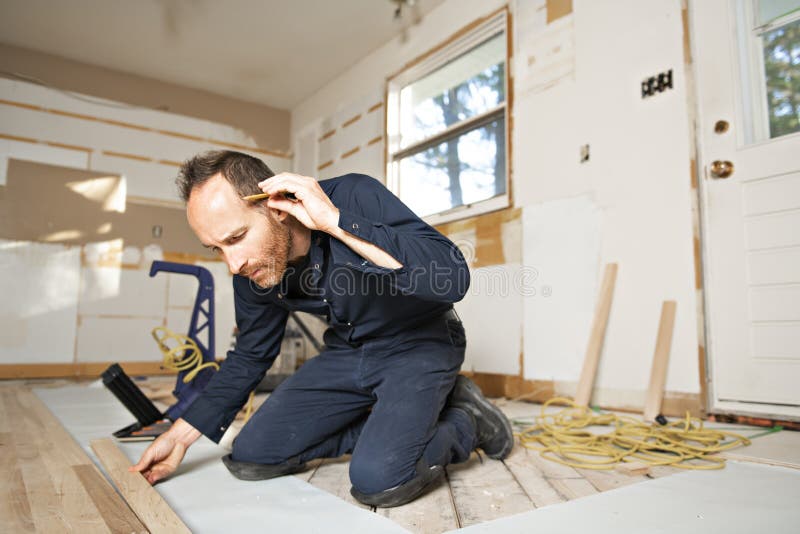 A Male Worker Install Wood Floor On A House Stock Image - Image of ...