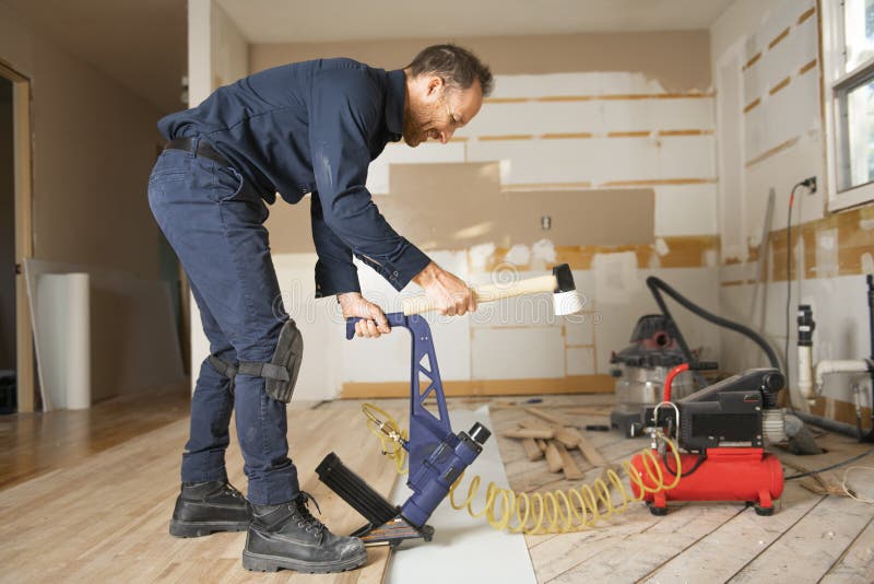 A Male Worker Install Wood Floor on a House Stock Photo - Image of ...