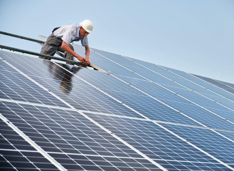 Male Worker Installing Solar Panels Under Blue Sky. Stock Photo - Image ...