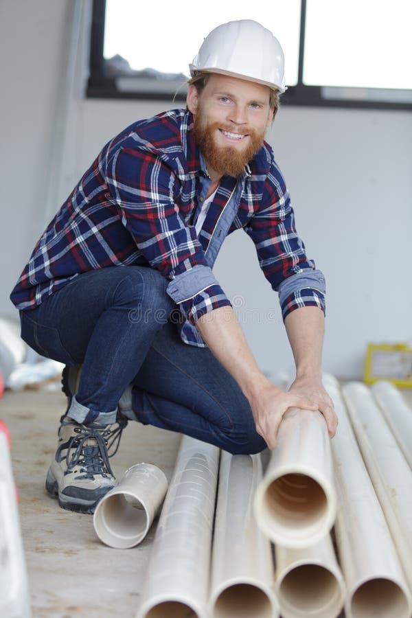 Male Worker Lifting Plastic Pipe Stock Photo - Image of property, beige ...