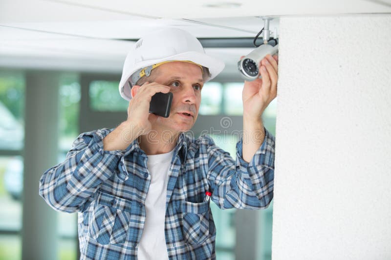 Male Worker on Phone Inspecting Security Camera Stock Photo - Image of ...