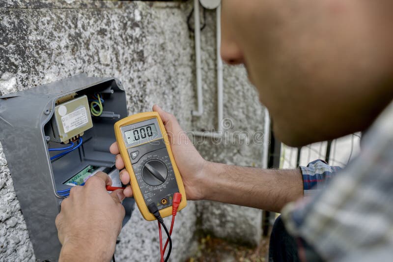 Man Using Multimeter On Exterior Electrical Box Stock Image - Image of ...