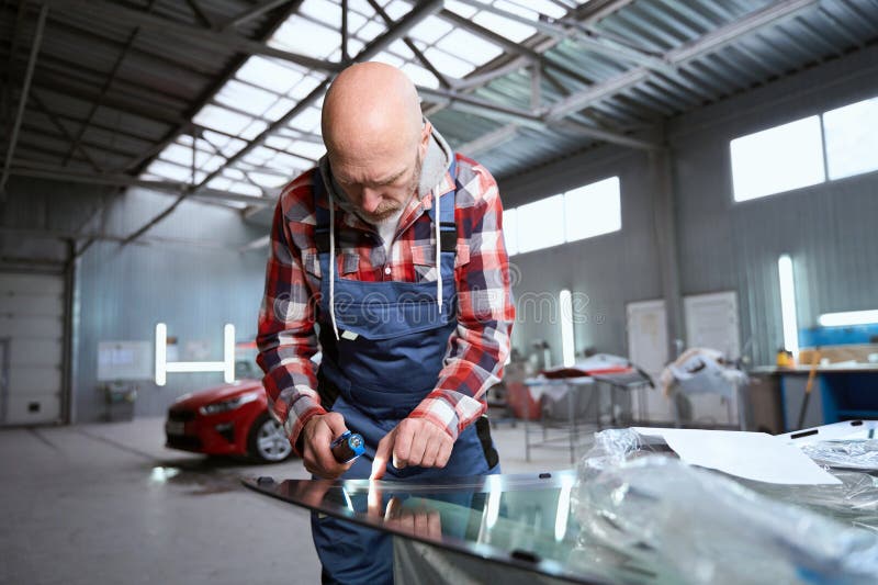 Male Worker in a Repair Shop Works with a Windshield Stock Photo ...