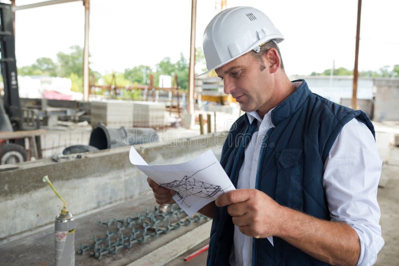 Male Worker on Site Looking at Plans Stock Image - Image of outdoors ...