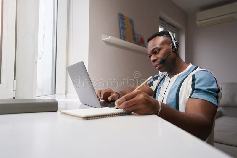 Man at Home Working at Laptop and Making Notes Stock Image - Image of ...