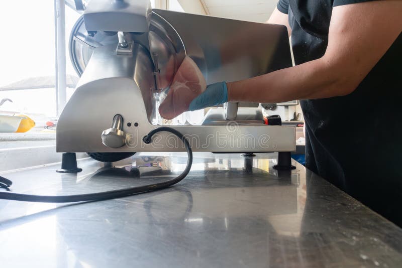 A Male Worker Sliced Ham Using a Slicing Machine on a Metal Table ...