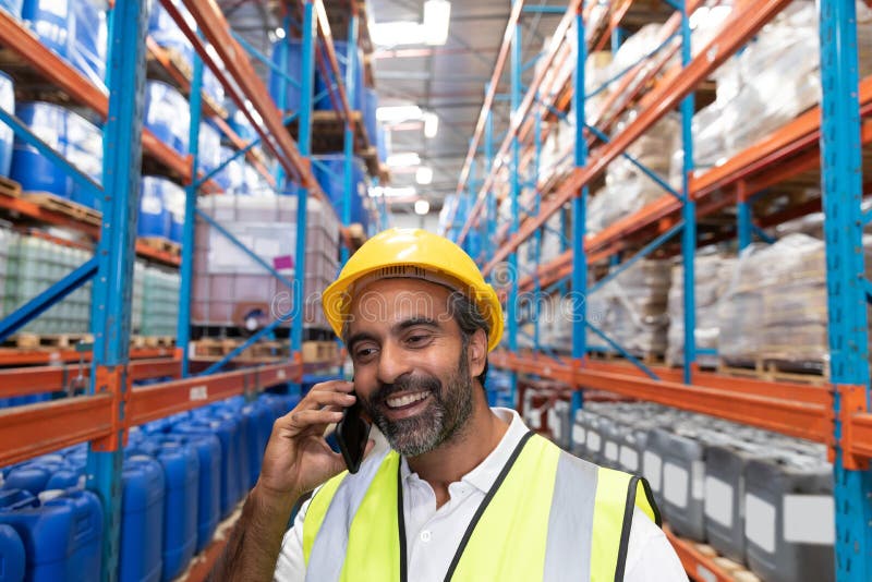 Male Worker Talking on Mobile Phone in Warehouse Stock Photo - Image of ...