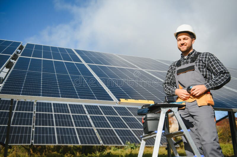 Male Worker in Uniform Outdoors with Solar Batteries at Sunny Day ...