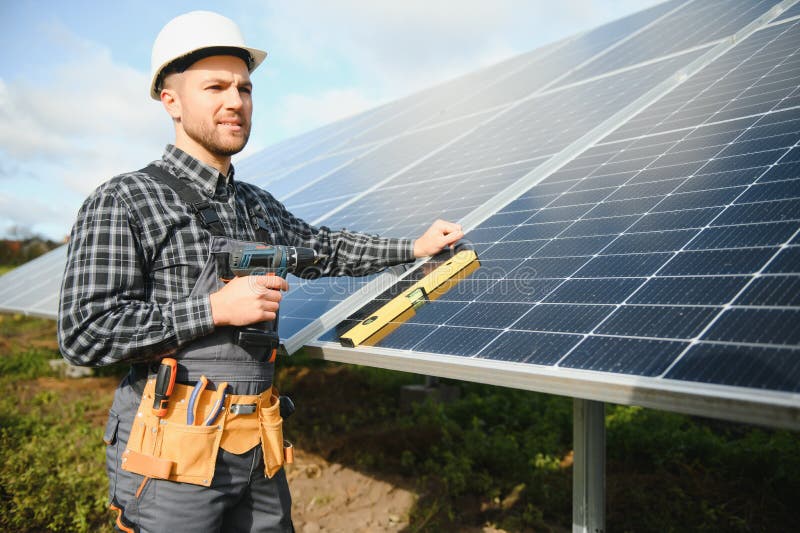 Male Worker in Uniform Outdoors with Solar Batteries at Sunny Day ...
