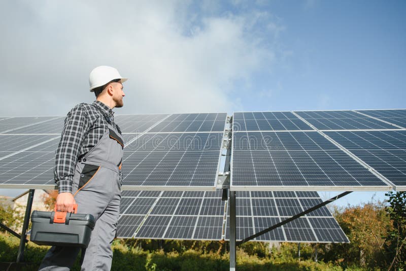 Male Worker in Uniform Outdoors with Solar Batteries at Sunny Day ...