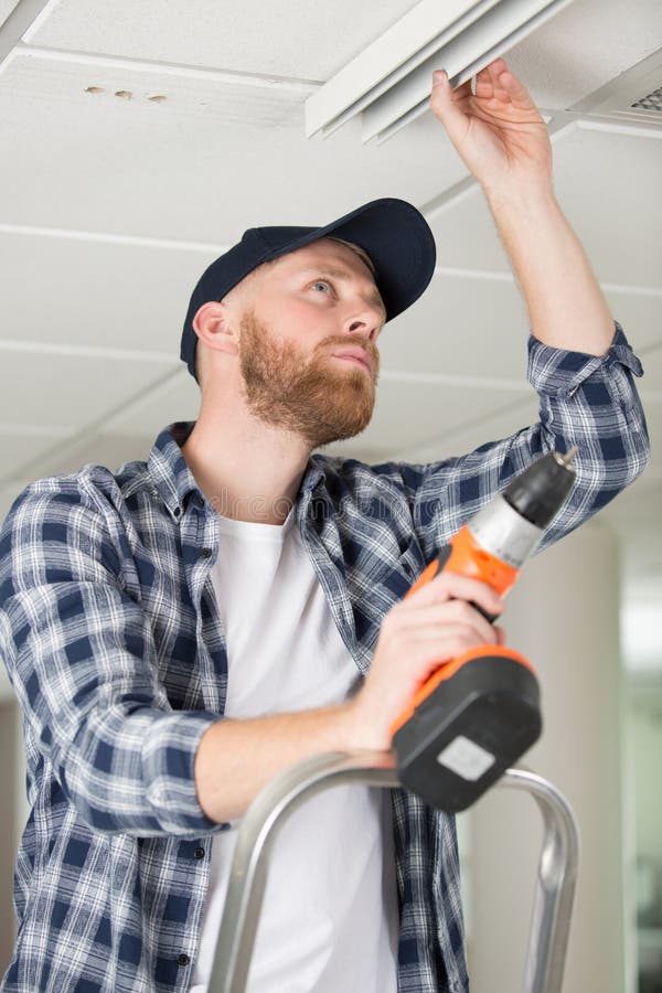 Male Worker Using Cordless Tool To Install New Light Stock Image ...