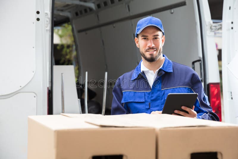Male Worker Using Tablet stock image. Image of boxes - 214043547