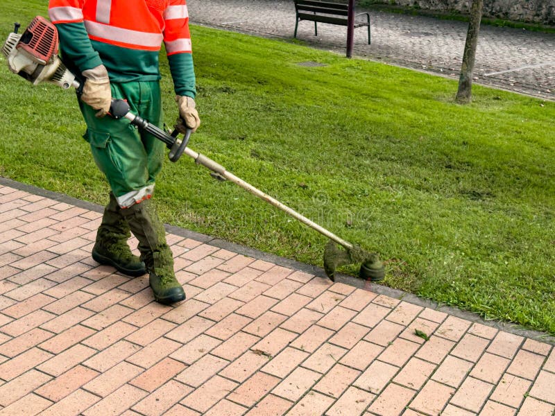 Male Worker Using Trimmer for Lawn Maintenance in Urban Park Stock ...