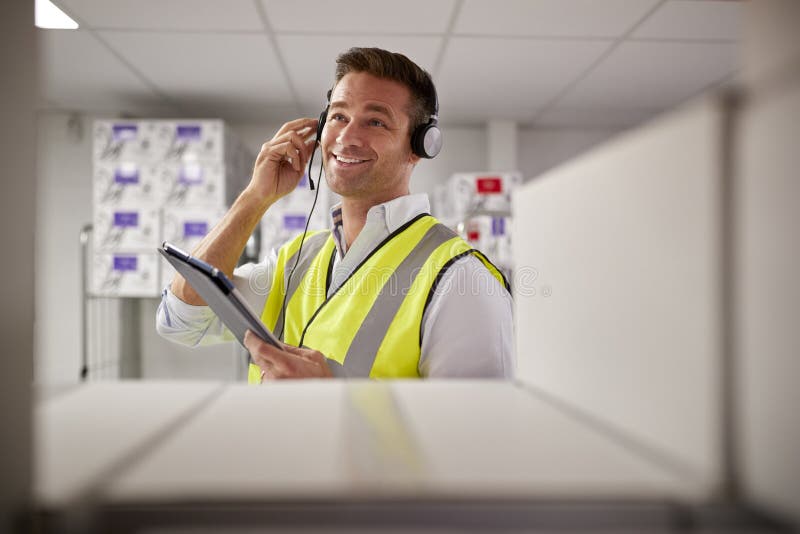 Male Worker Wearing Headset in Logistics Distribution Warehouse with ...