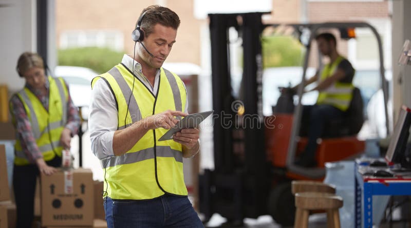 Male Worker Wearing Headset in Logistics Distribution Warehouse Using ...
