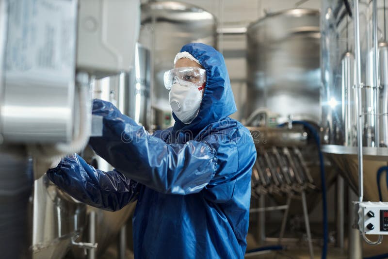 Worker in Protective Gear Operating Equipment at Factory Stock Photo ...