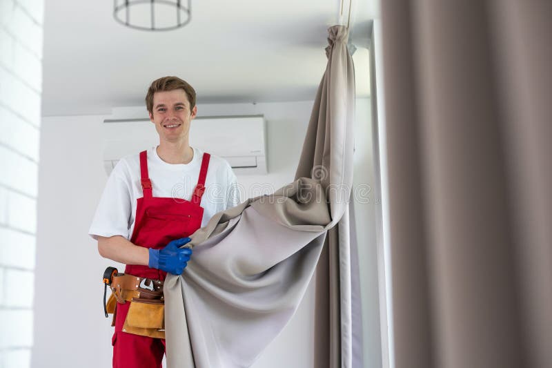 A Male Worker Who Installs a Curtain. Stock Image - Image of measure ...