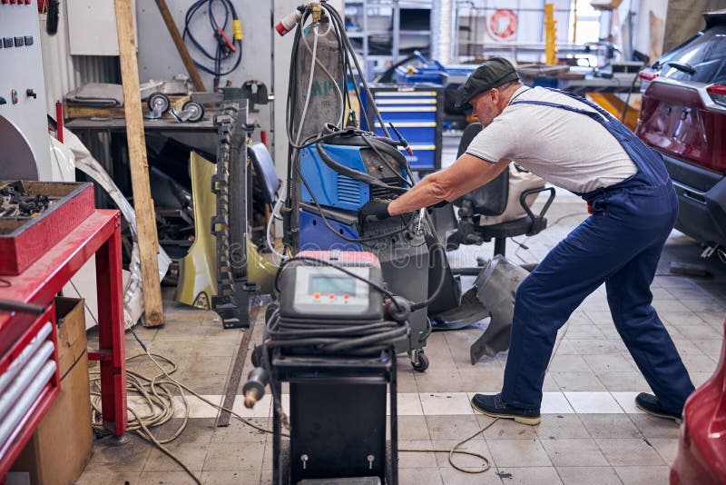 Auto Mechanic Using Battery Charger at Car Repair Shop Stock Photo ...