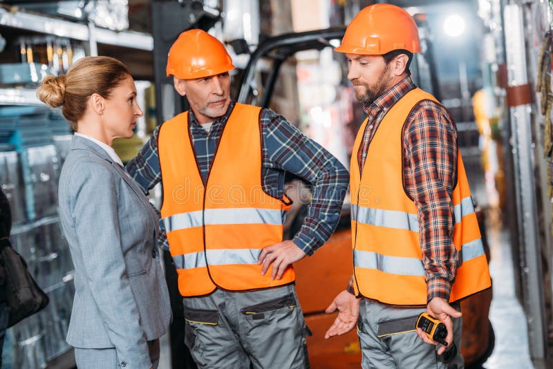 Male Workers in Safety Vests and Helmets Talking with Inspector Stock ...