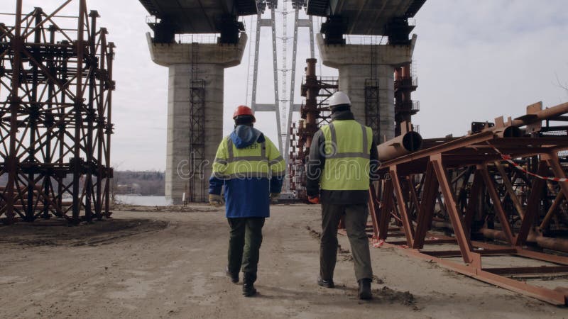 Male Workers Walking and Discussing Bridge Construction Stock Image ...
