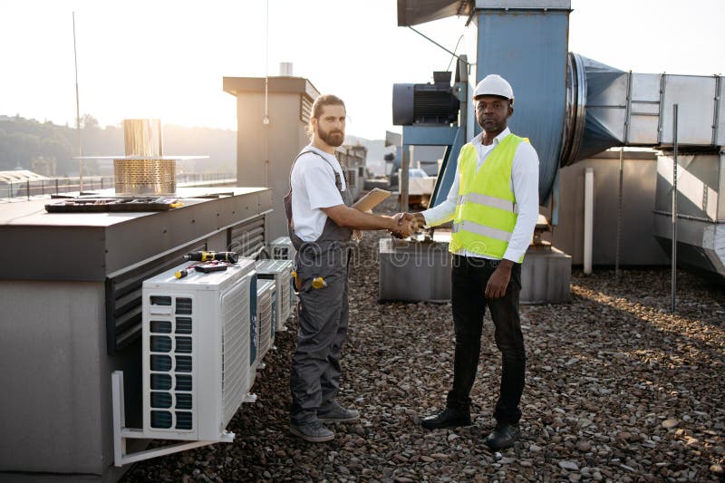 Males Engineers Standing and Shaking Hands on Roof Stock Photo - Image ...