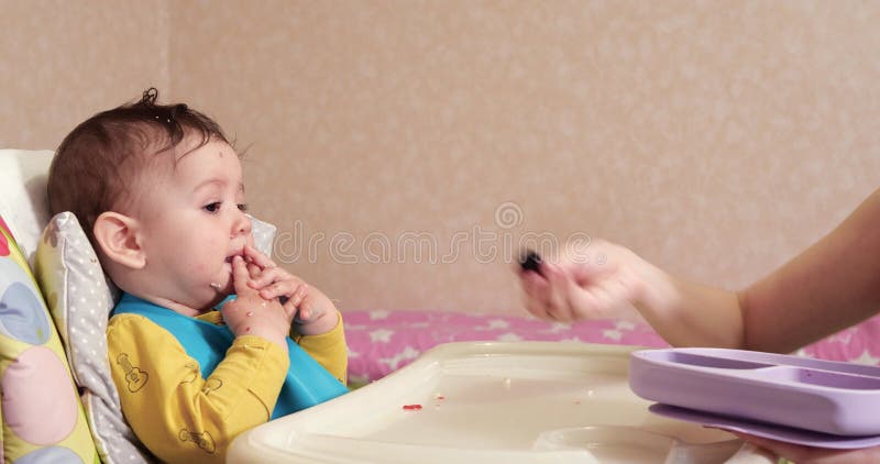 Mamá Alimenta Al Niño Con Una Cuchara Y La Mano De La Comida Familiar Y