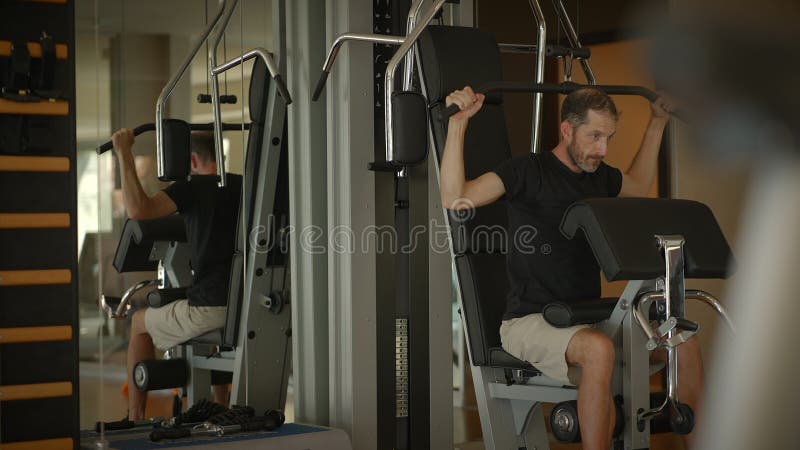 A Man Engaging in Physical Exercise at the Gym Strength Training and ...