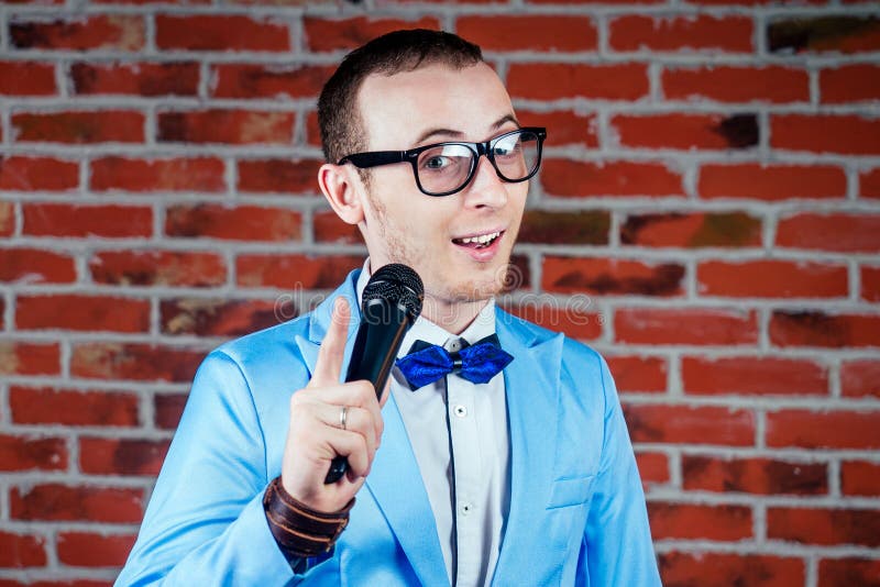 A Man Actor Comedian In Glasses A Stylish And Tie Suit Holds A Microphone Concept Of Public